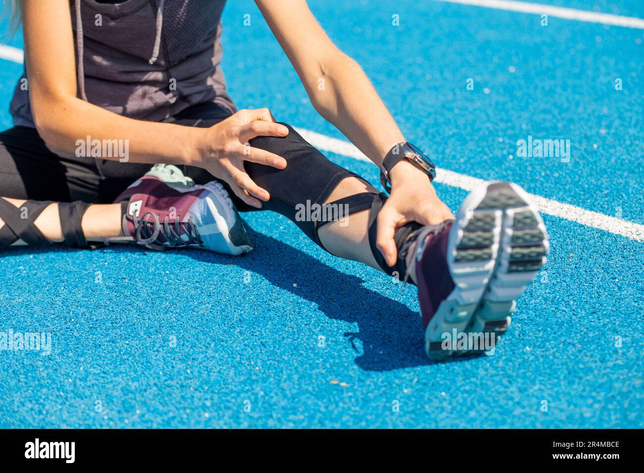 Female track and field athlete doing stretching exercises (symbol image ...