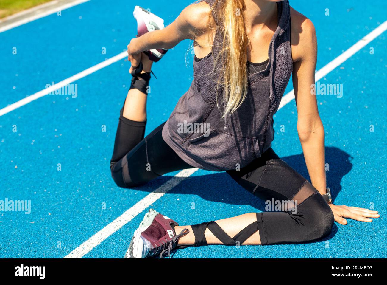 Female track and field athlete doing stretching exercises (symbol image ...