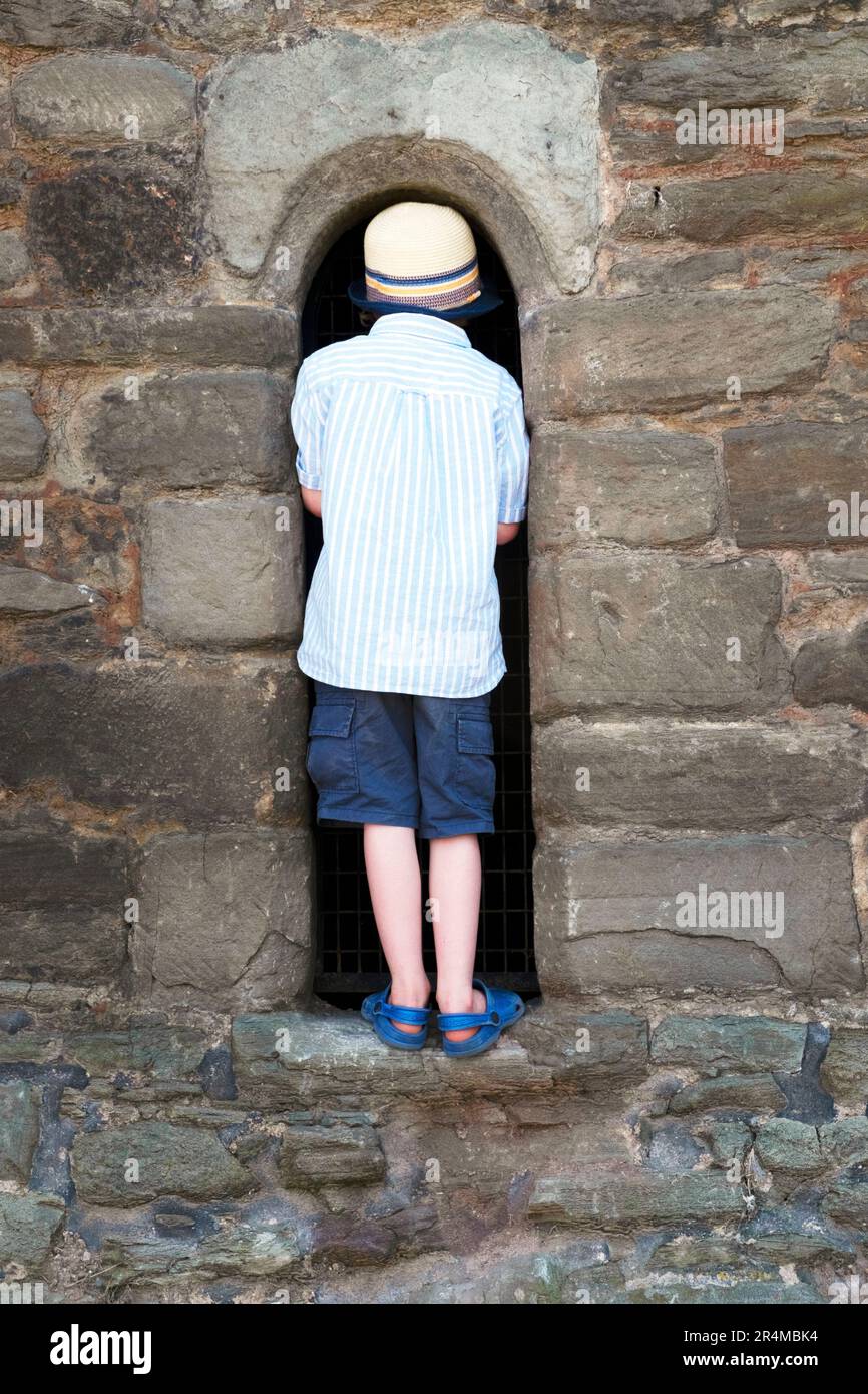 Rear view of boy child fitting perfectly into the window of Hay Castle ...
