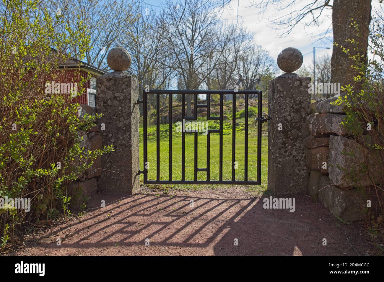 Entrance of a graveyard with old wrought iron gate on stone posts Stock ...