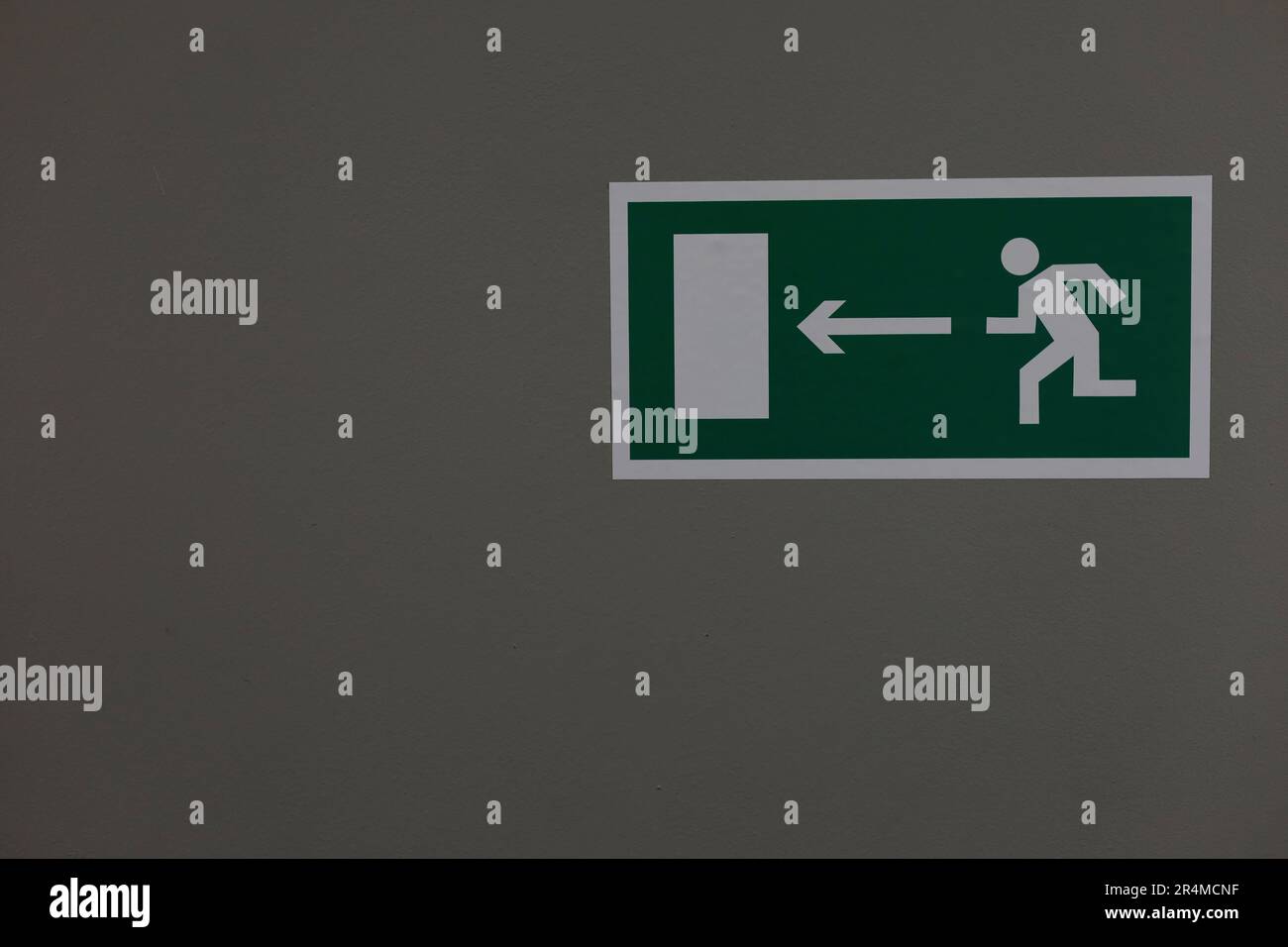 Fire exit sign in the corridor of the building, gray background Stock ...