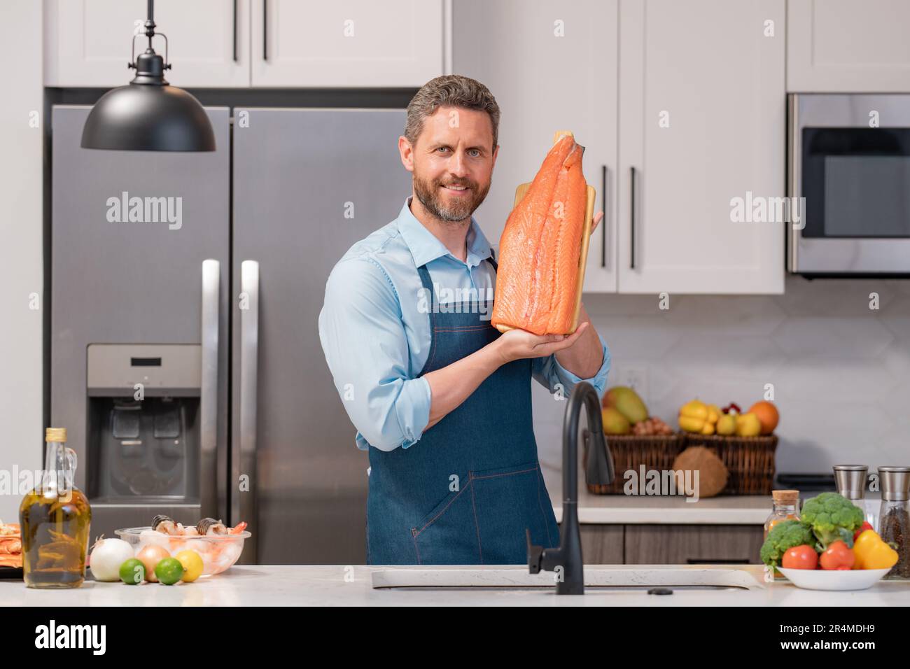 Chef man in cook apron cooking seafood crab and shrimp, salmon and ...