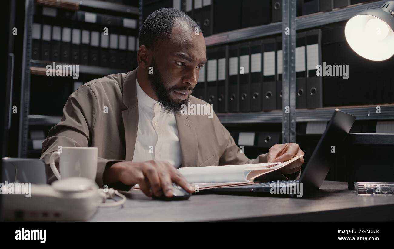 Male inspector reading witness statements and clues Stock Photo - Alamy