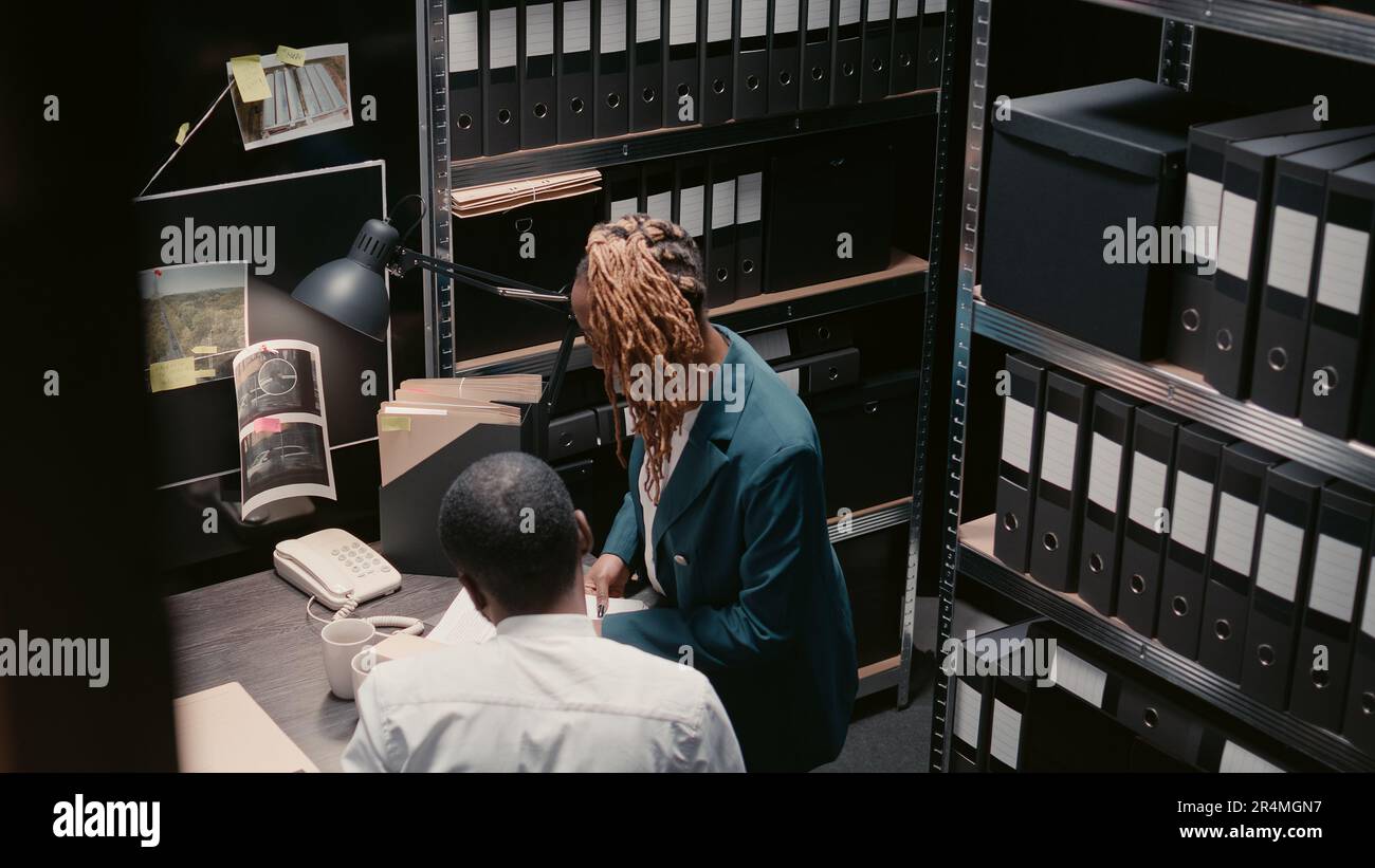 Two police officers talking about surveillance footage Stock Photo - Alamy