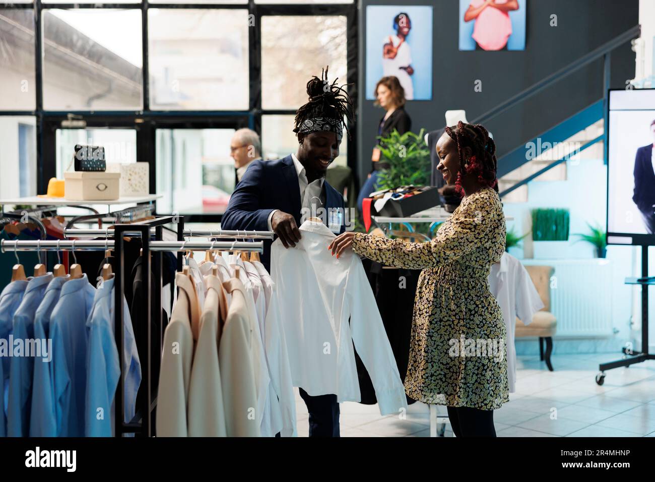 Showroom manager helping client with white shirt Stock Photo - Alamy