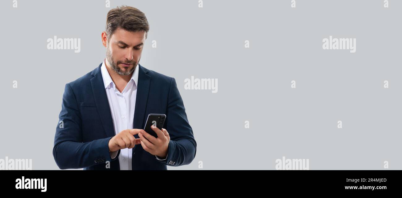 Man in suit using mobile phone isolated on studio background. Portrait ...