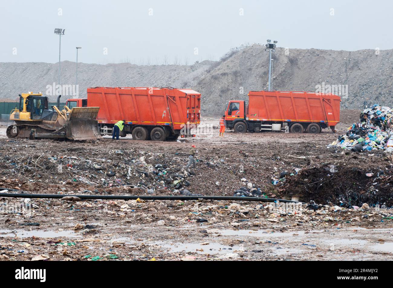 Dump municipal waste. Workers with trucks and bulldozers at work in ...