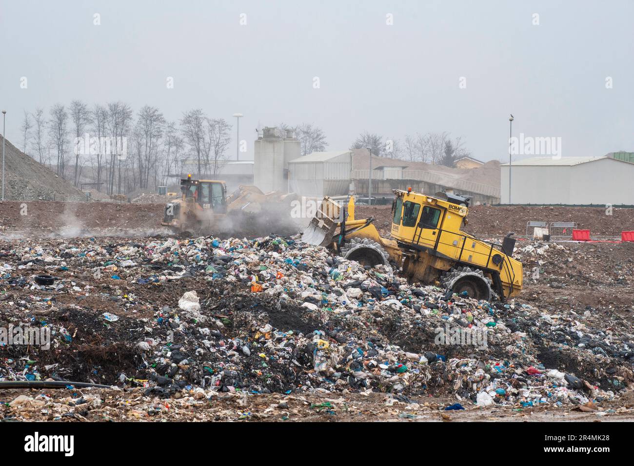 Dump municipal waste. Workers with trucks and bulldozers at work in ...