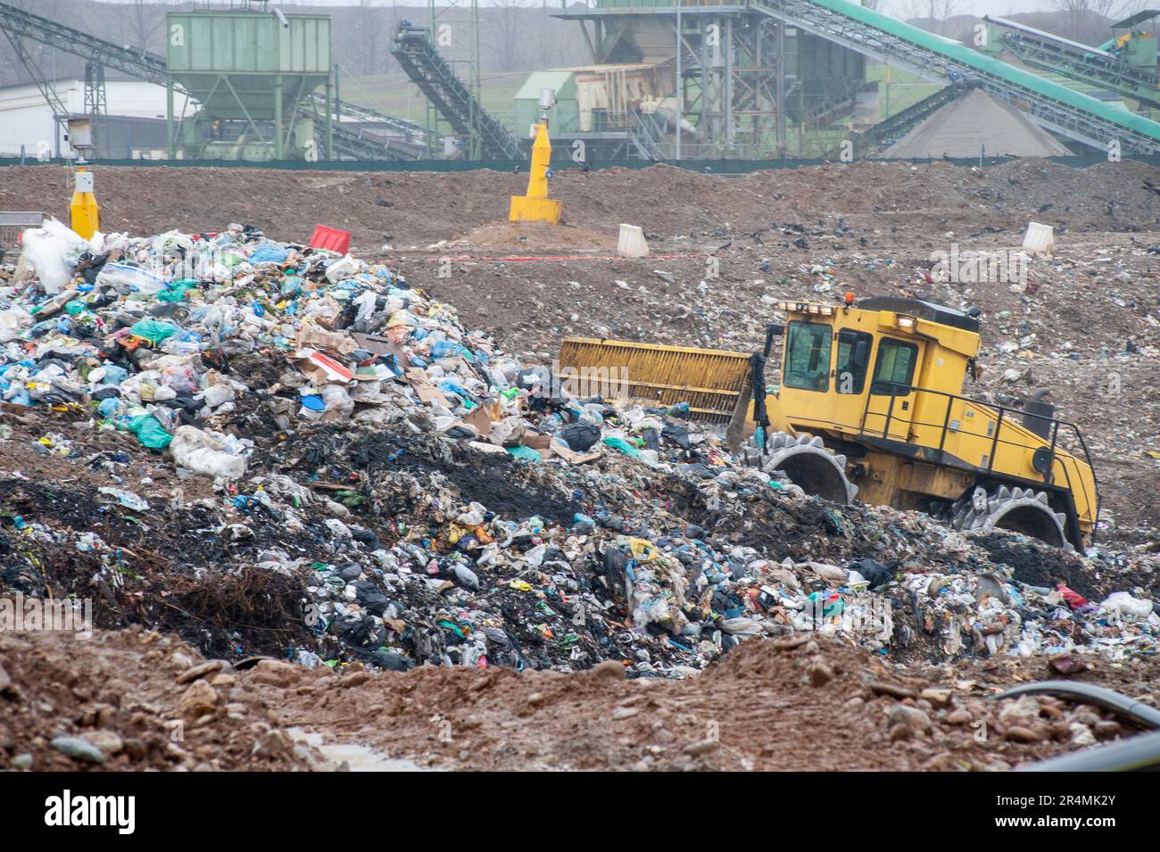 Dump municipal waste. Workers with trucks and bulldozers at work in ...