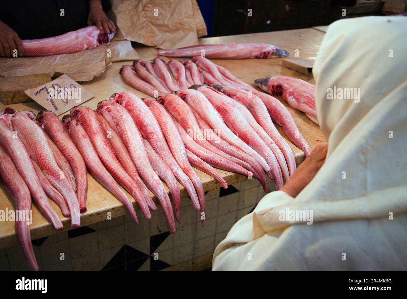 A fishmonger selling fish to a Muslim woman wearing white Hijab Stock ...