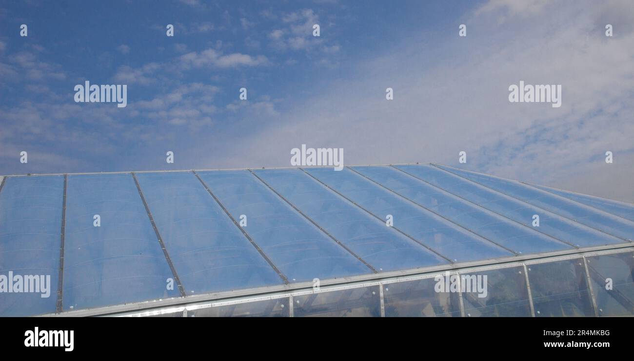 Clear blue sky with blue roofs with one roof tile in a different color ...