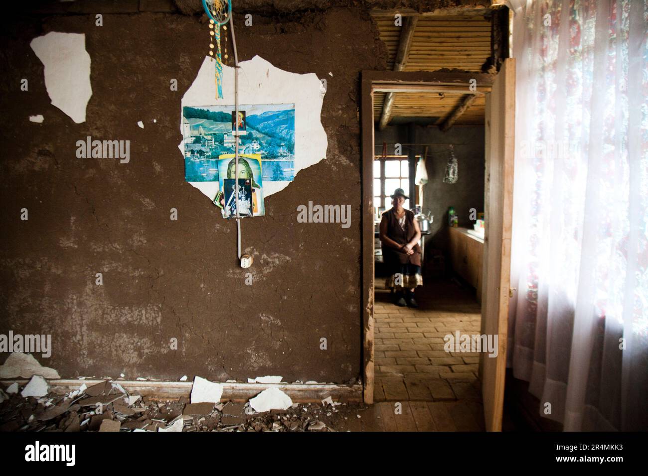 A woman shows off the inside of a home that has been badly damaged by ...