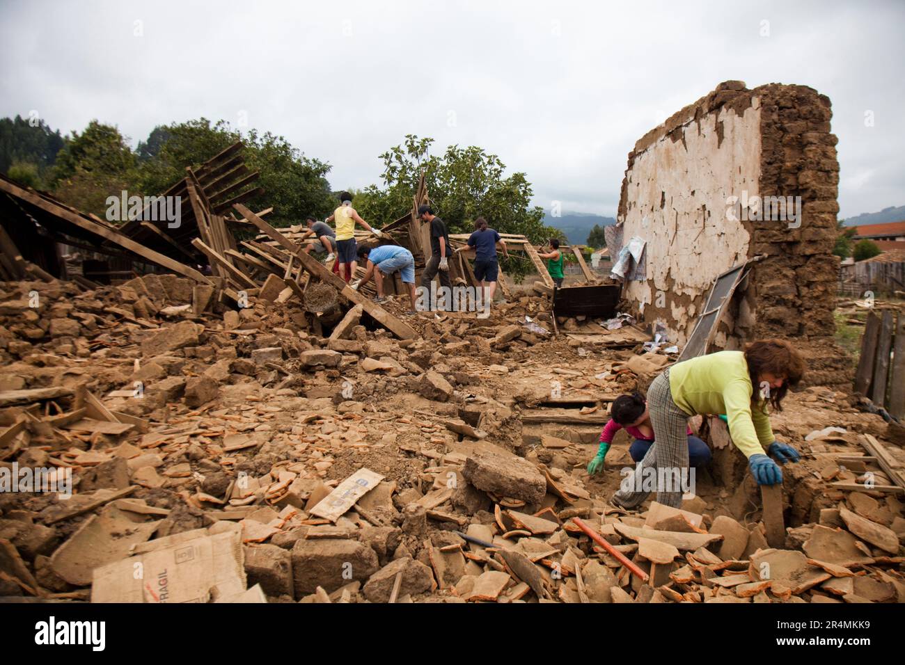 Local people sort through the rubble of a collapsed building, destroyed ...