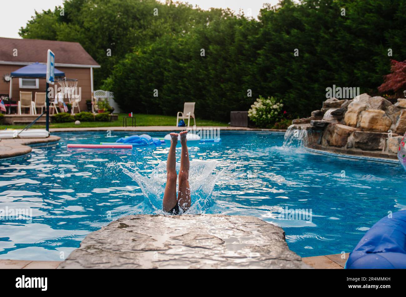 Girl diving into pool half in water with legs and splash Stock Photo ...