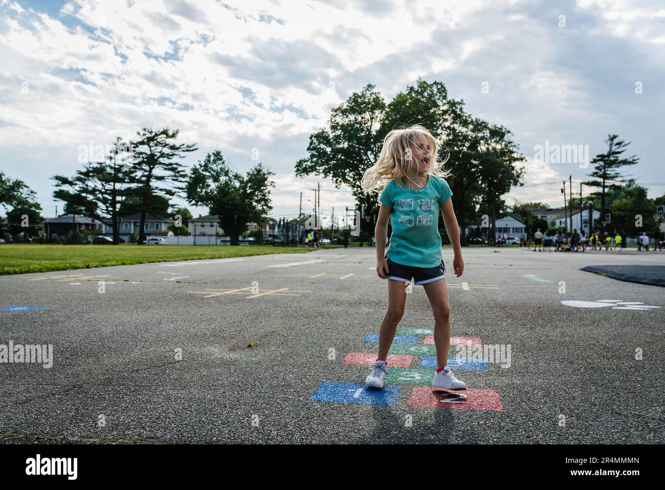 Girl playing hopscotch on blacktop in suburbs Stock Photo - Alamy