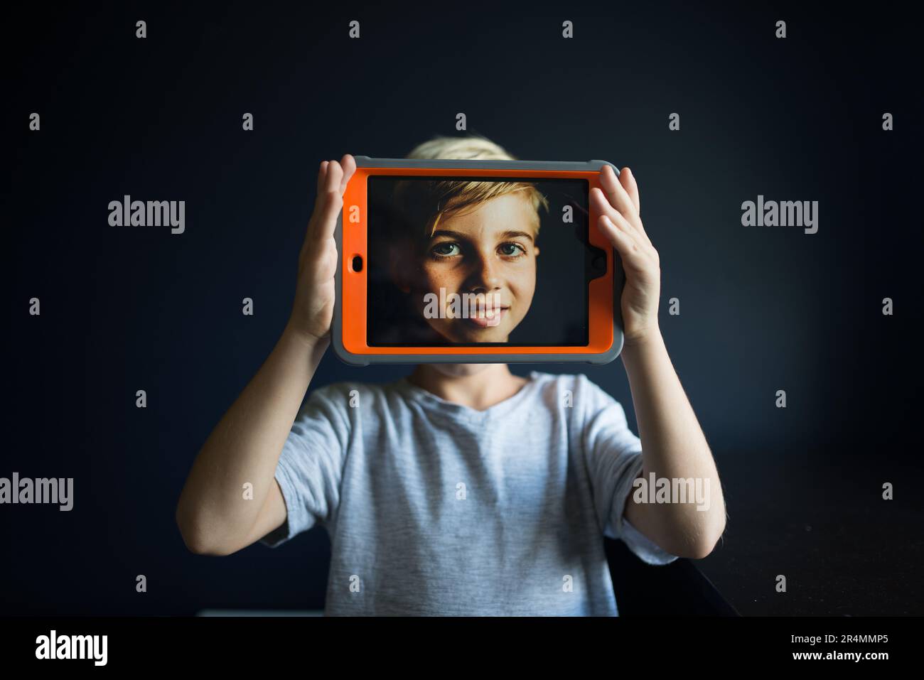 Boy with iPad in front of face Stock Photo - Alamy