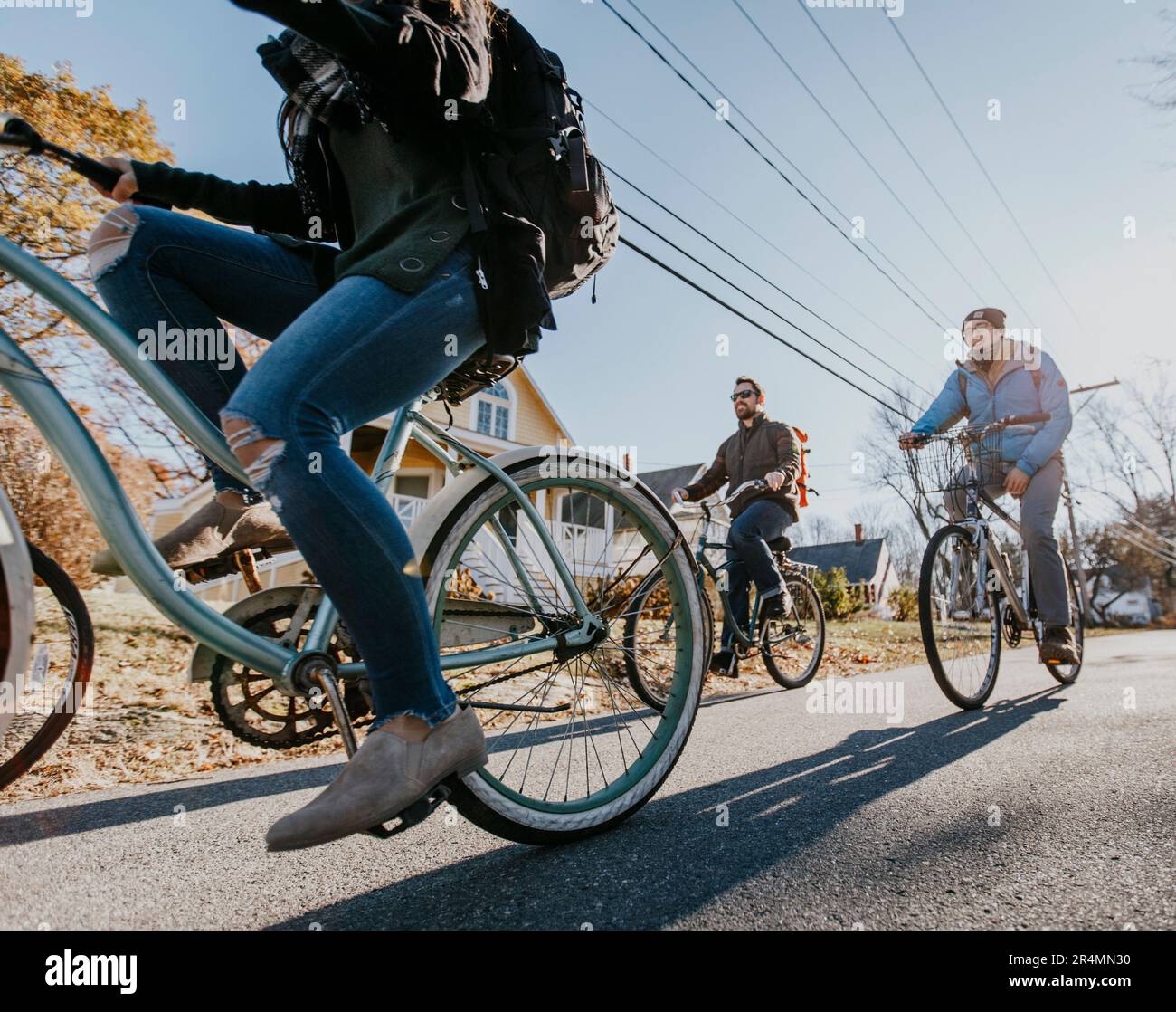 A group of friends ride their bikes through a village in Maine Stock ...