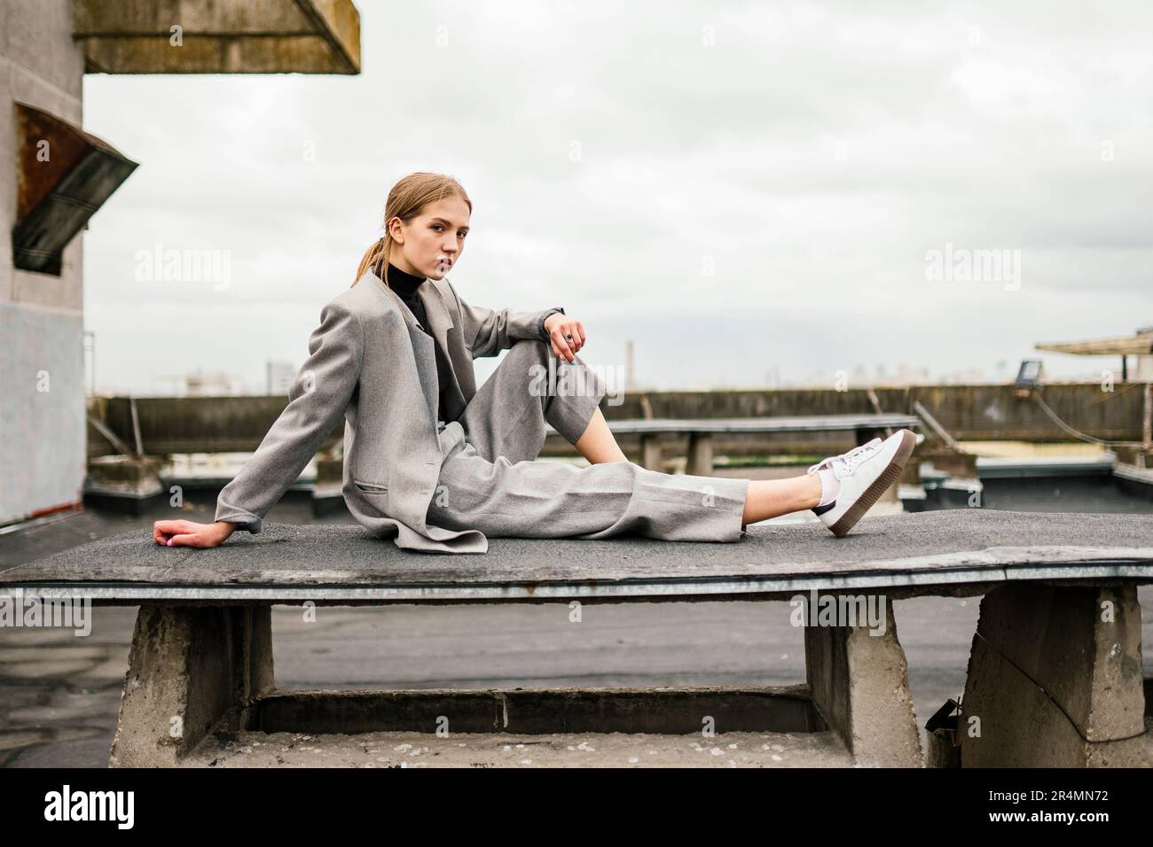 woman sitting on the roof of a building Stock Photo - Alamy