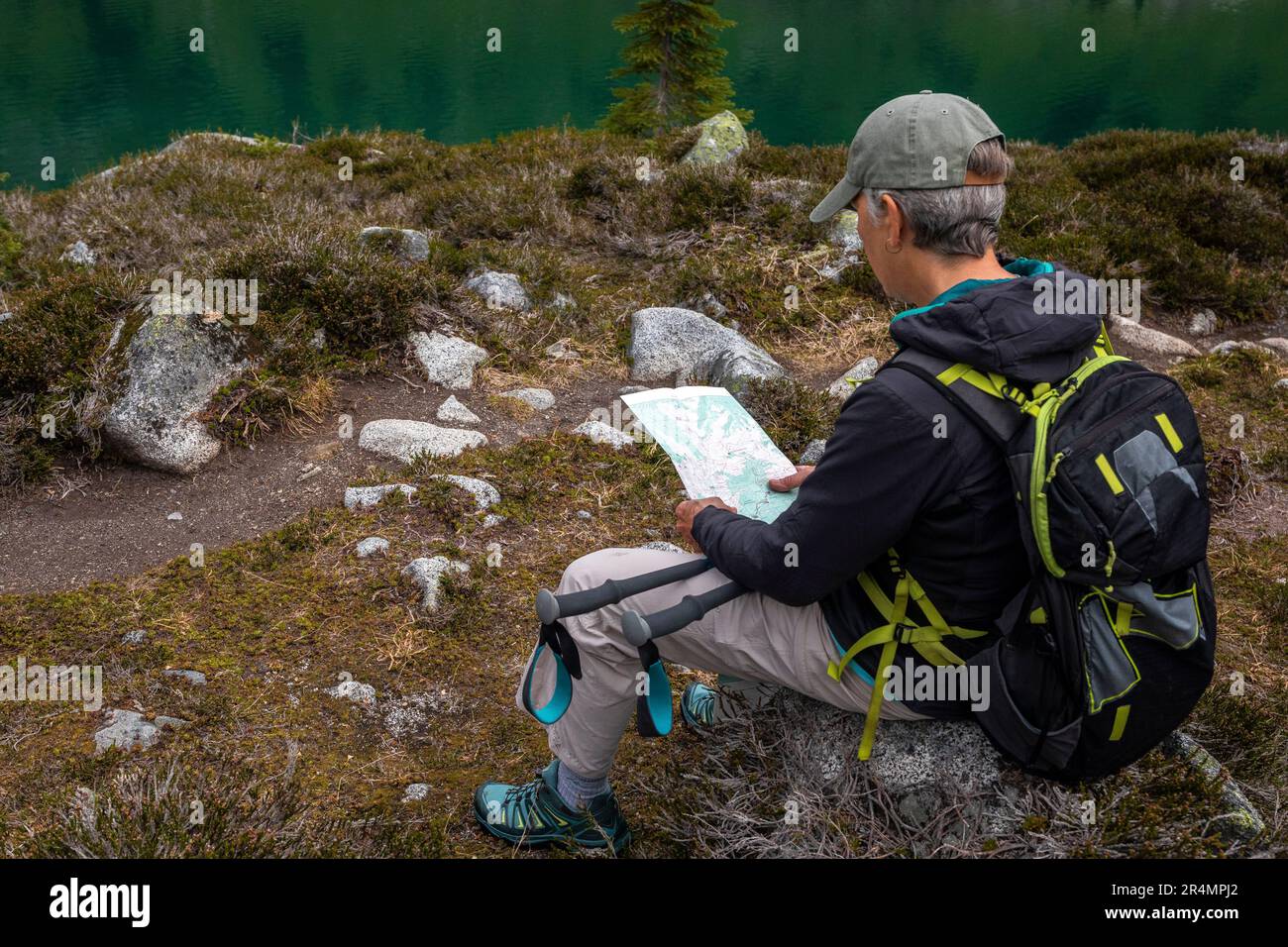 Side view of a women with backpack looking at a map while hiking Stock ...
