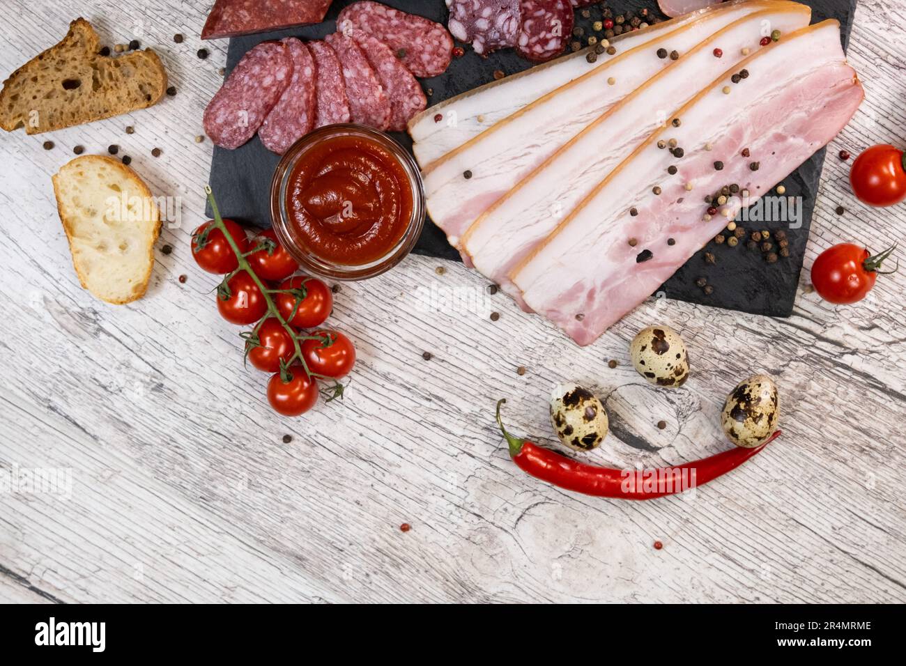 Antipasti different types of sausages and lard on a graphite board .Top ...