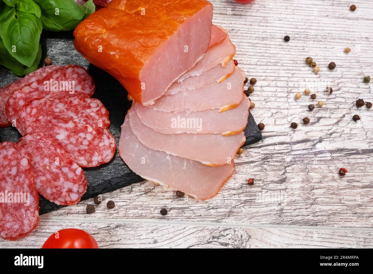 Antipasti different types of sausages and lard on a graphite board .Top ...