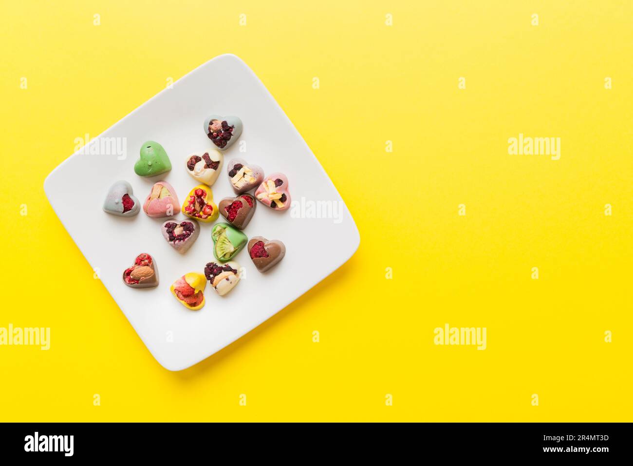 Plate with different chocolate on colored background. Assortment of ...