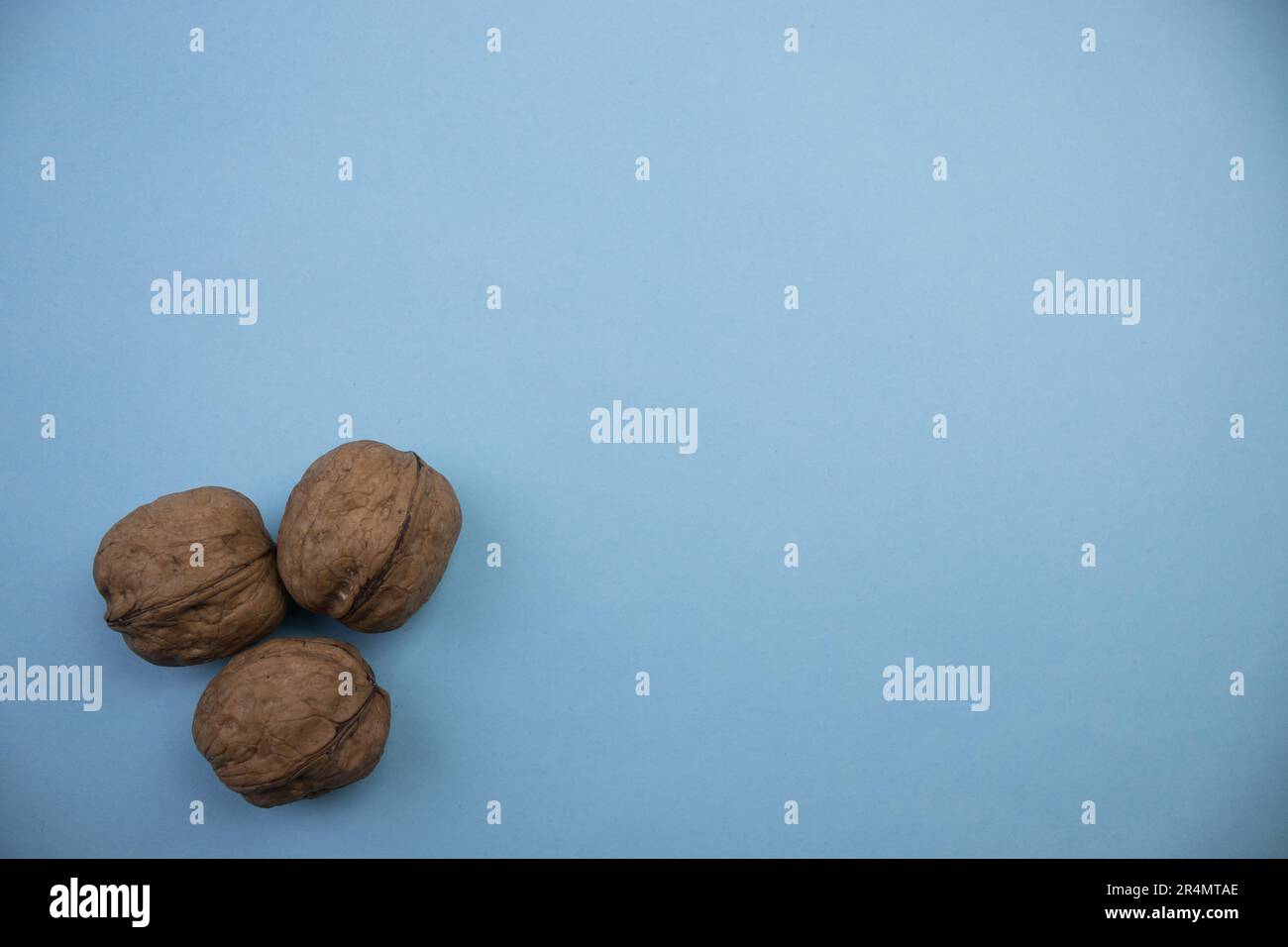 Three walnuts in shell, photographed from above, placed on the edge of ...