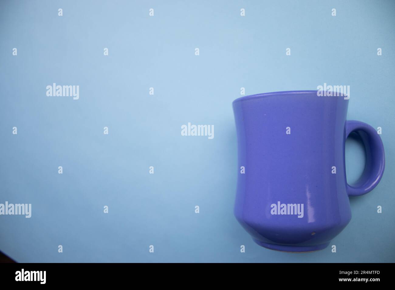 Blue mug, photographed from above, placed on the edge of a blue ...