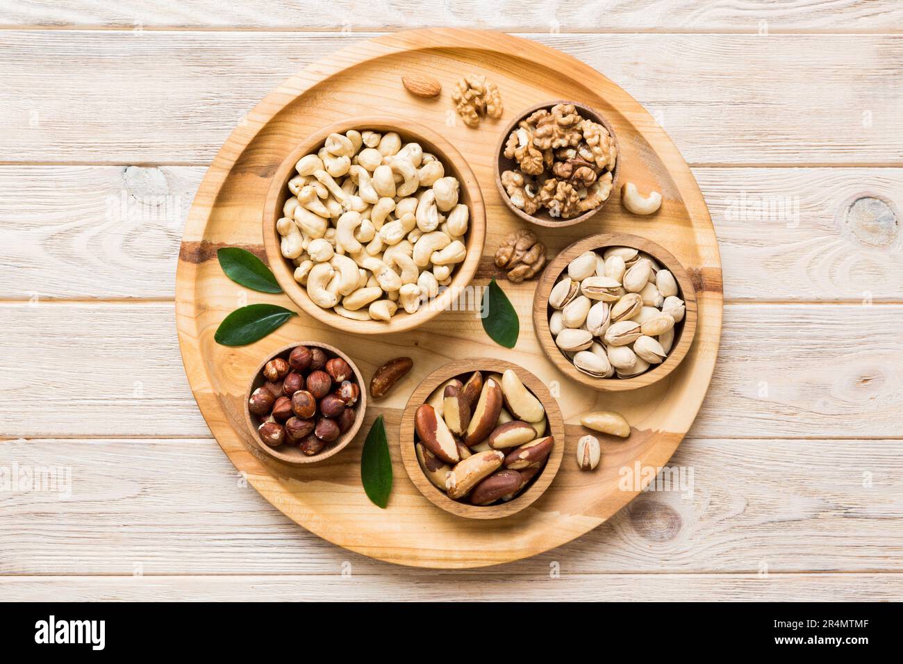 mixed nuts in wooden bowl. Mix of various nuts on colored background ...