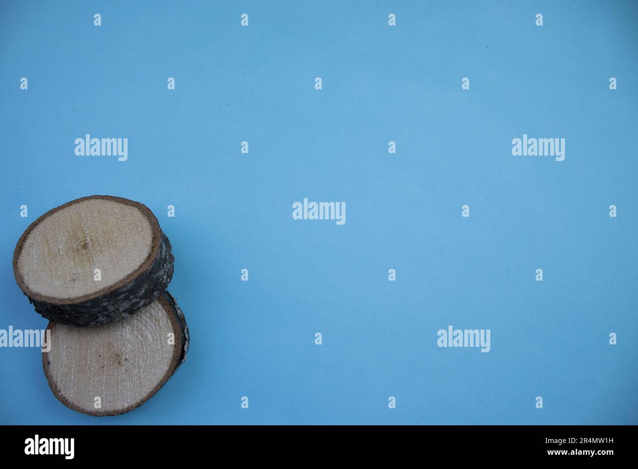 Small round logs, photographed from above, placed on the edge of a blue ...