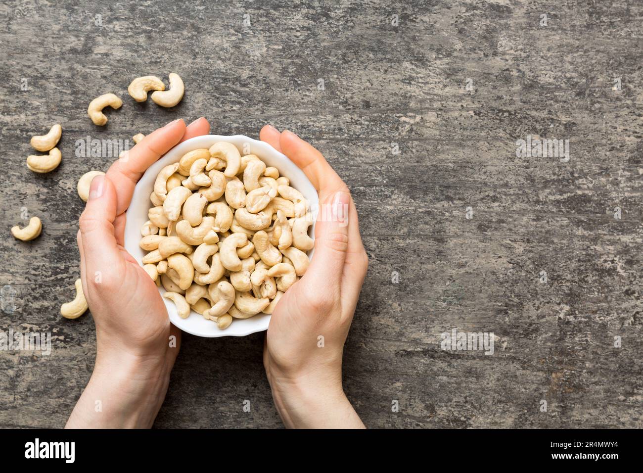 Woman hands holding a wooden bowl with cashew nuts. Healthy food and snack. Vegetarian snacks of ...
