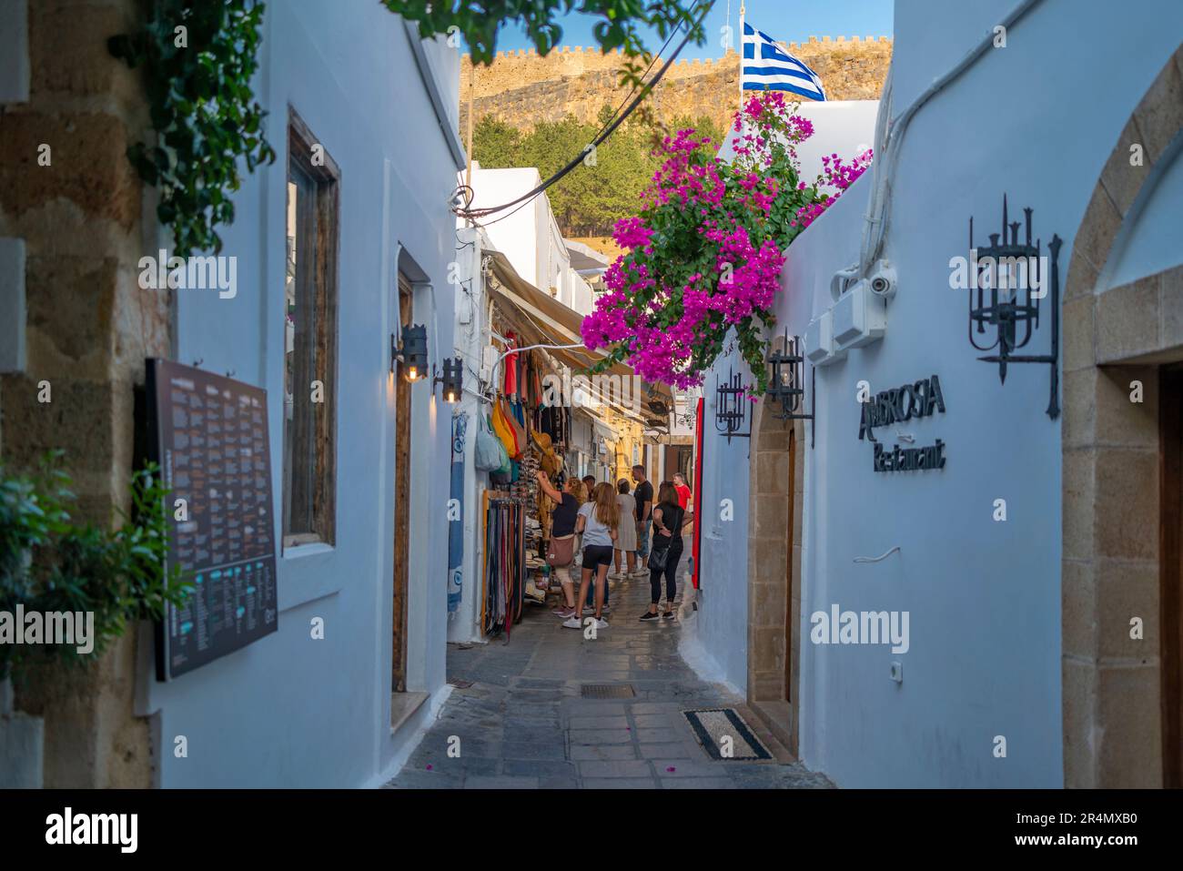 View of Lindos Acropolis from a Lindos street at sunset, Lindos, Rhodes ...