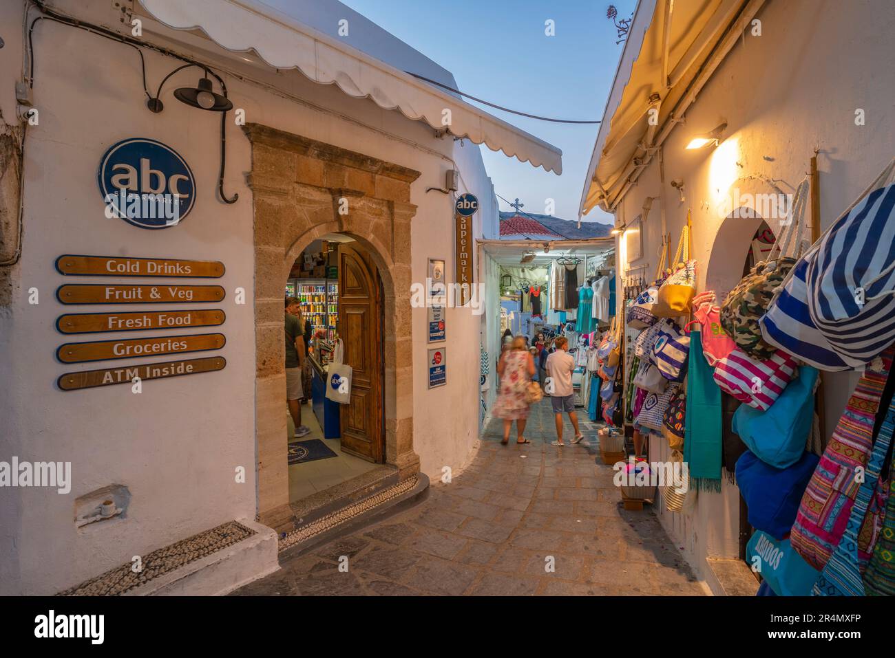 View of shops in Lindos street at dusk, Lindos, Rhodes, Dodecanese ...