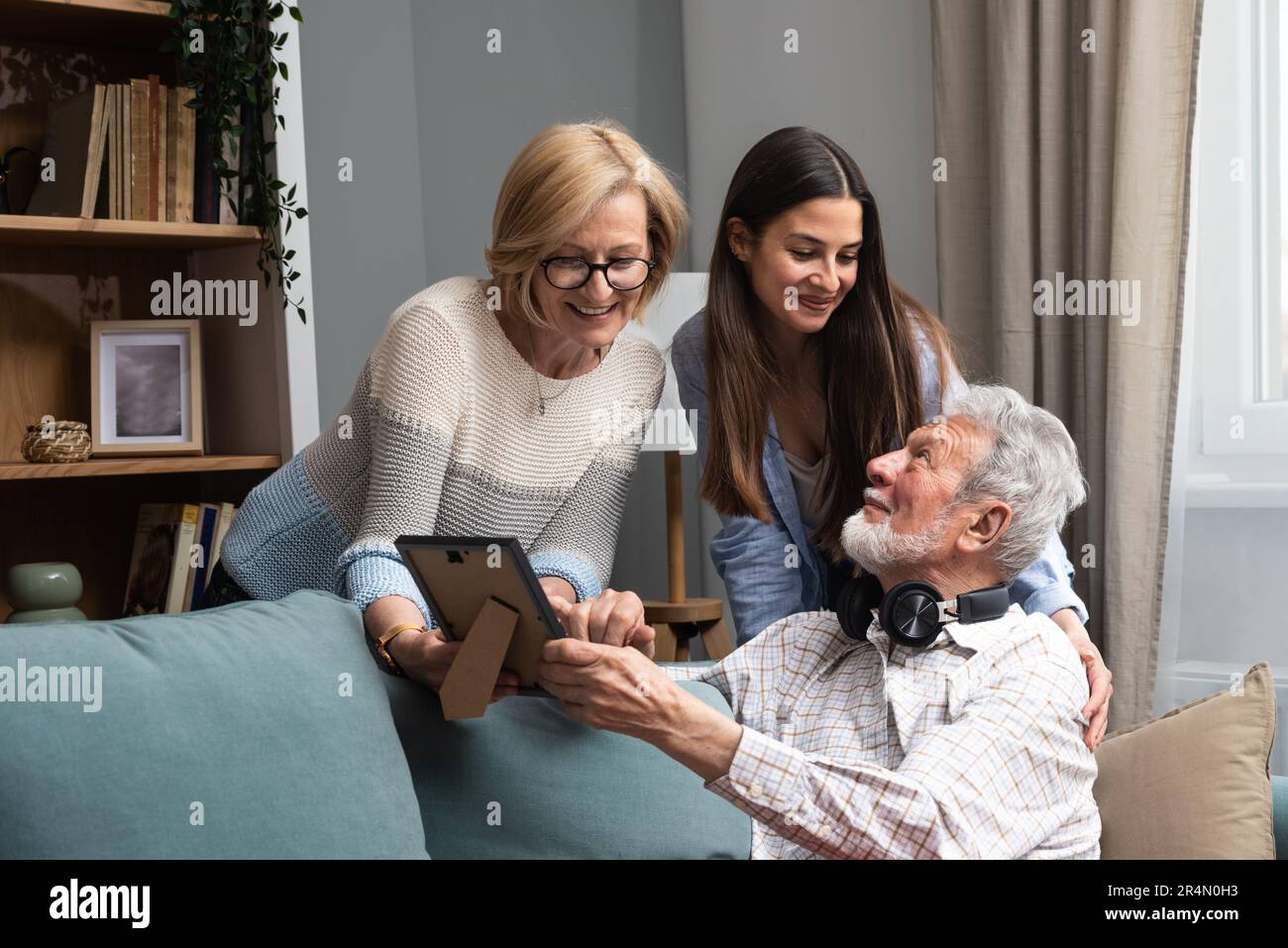 Happy three-generation family hugging sit indoors enjoy time together ...