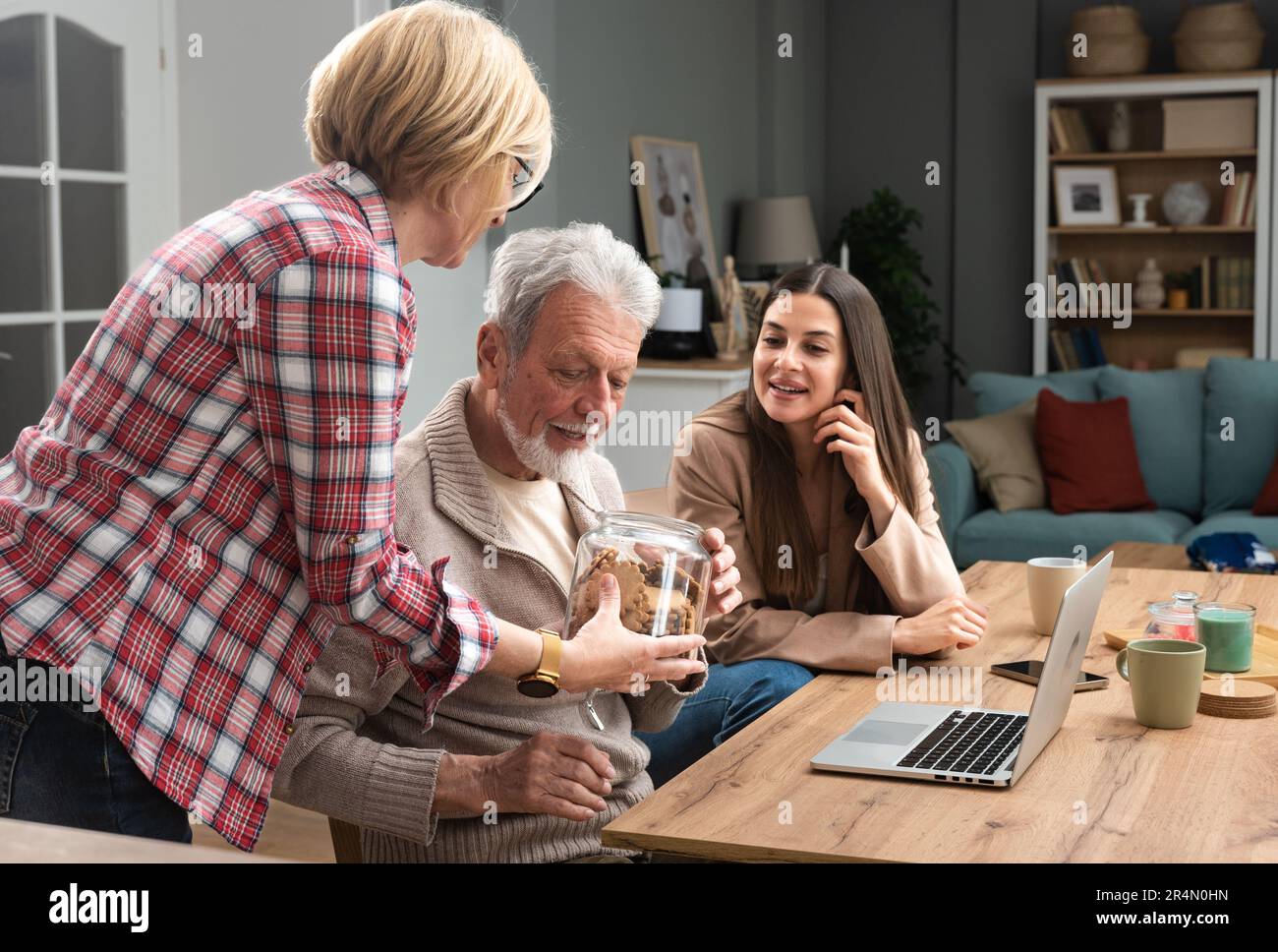 Happy three-generation family hugging sit indoors enjoy time together ...
