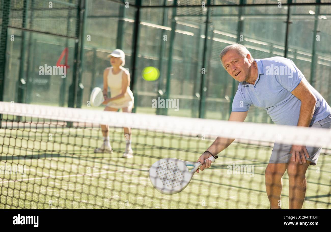 Old man playing Padel Tennis in open-air tennis court Stock Photo - Alamy