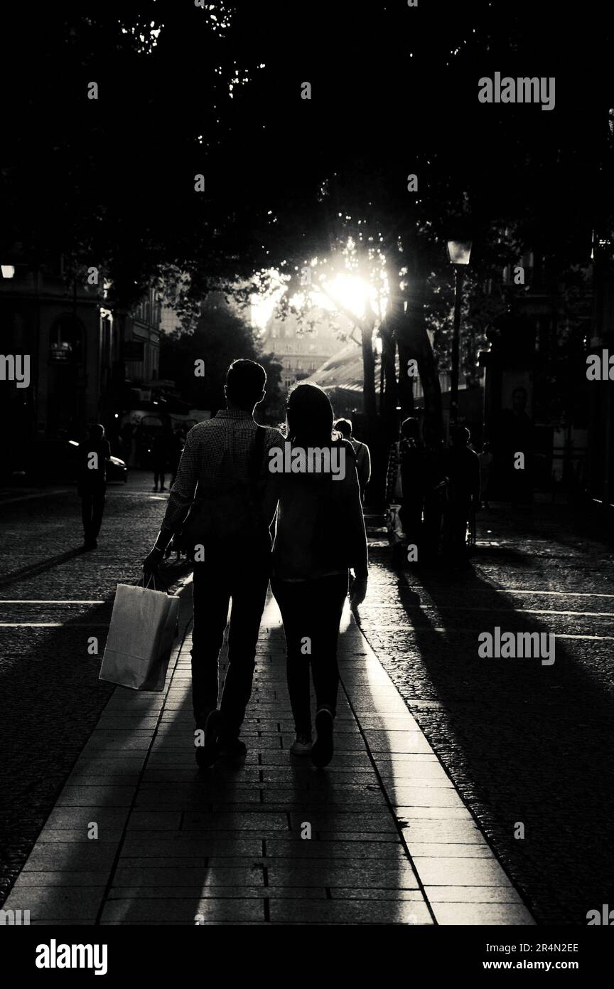 Couple after shopping walking at Parisian pedestrian street in golden ...