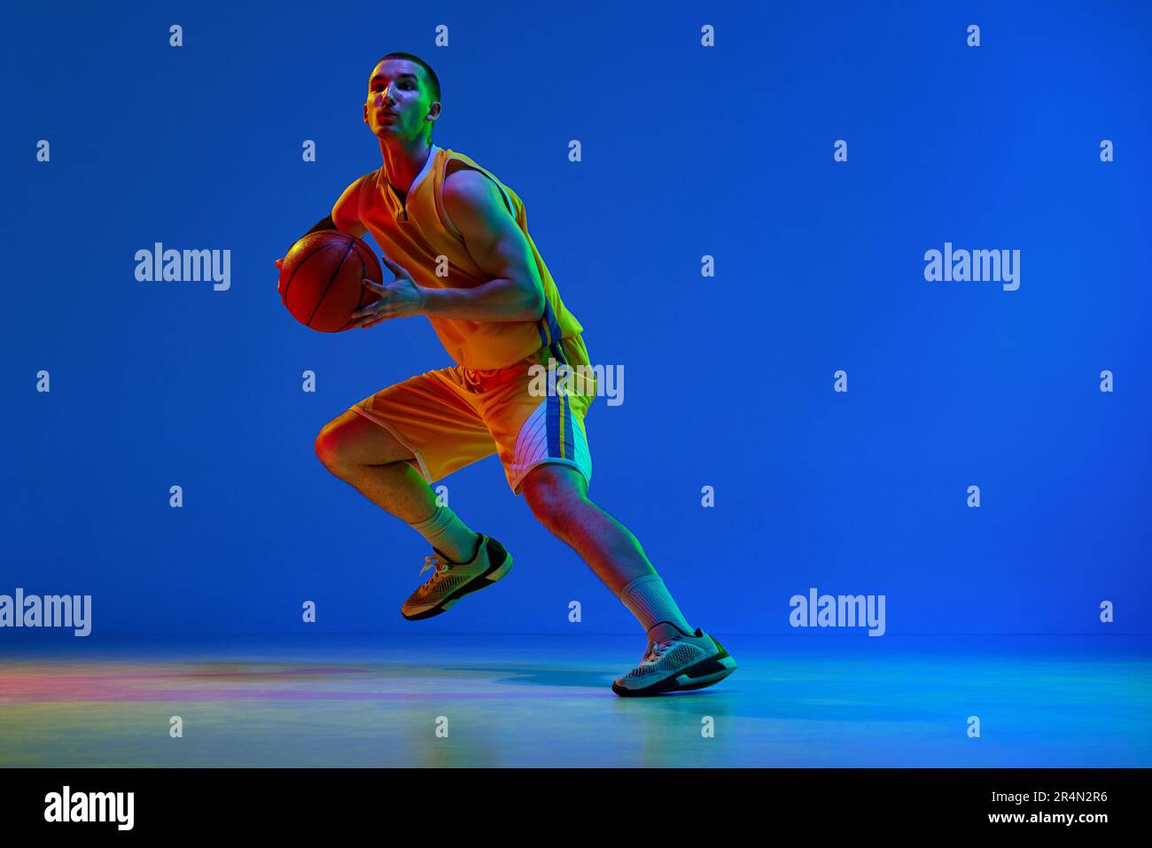 Dynamic image of young basketball player in yellow uniform during game ...