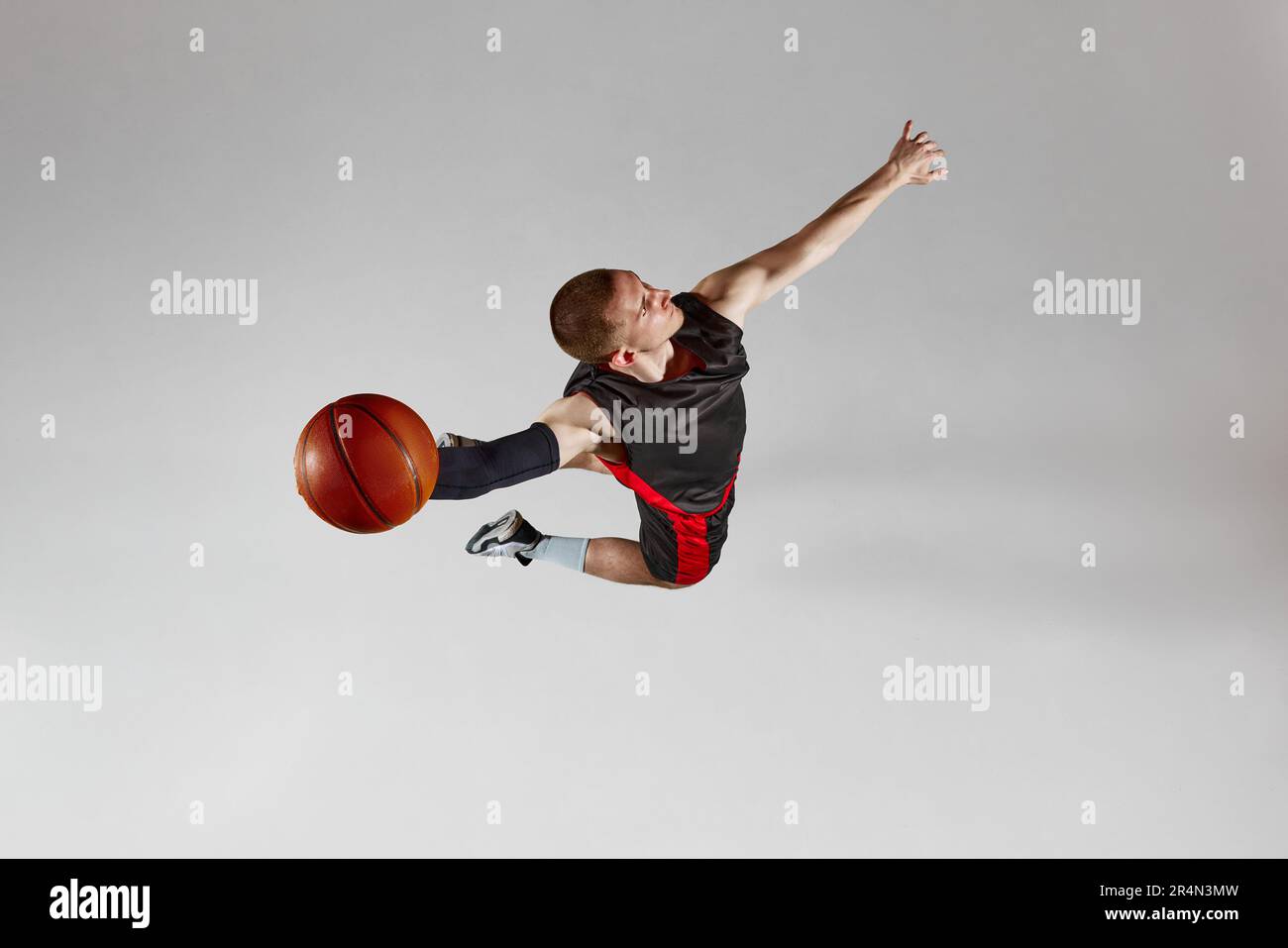 Dynamic image of male basketball player in motion, jumping with ball ...