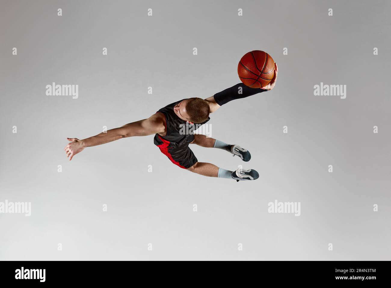 Winning goal. Sportive young man, basketball player in motion, jumping ...
