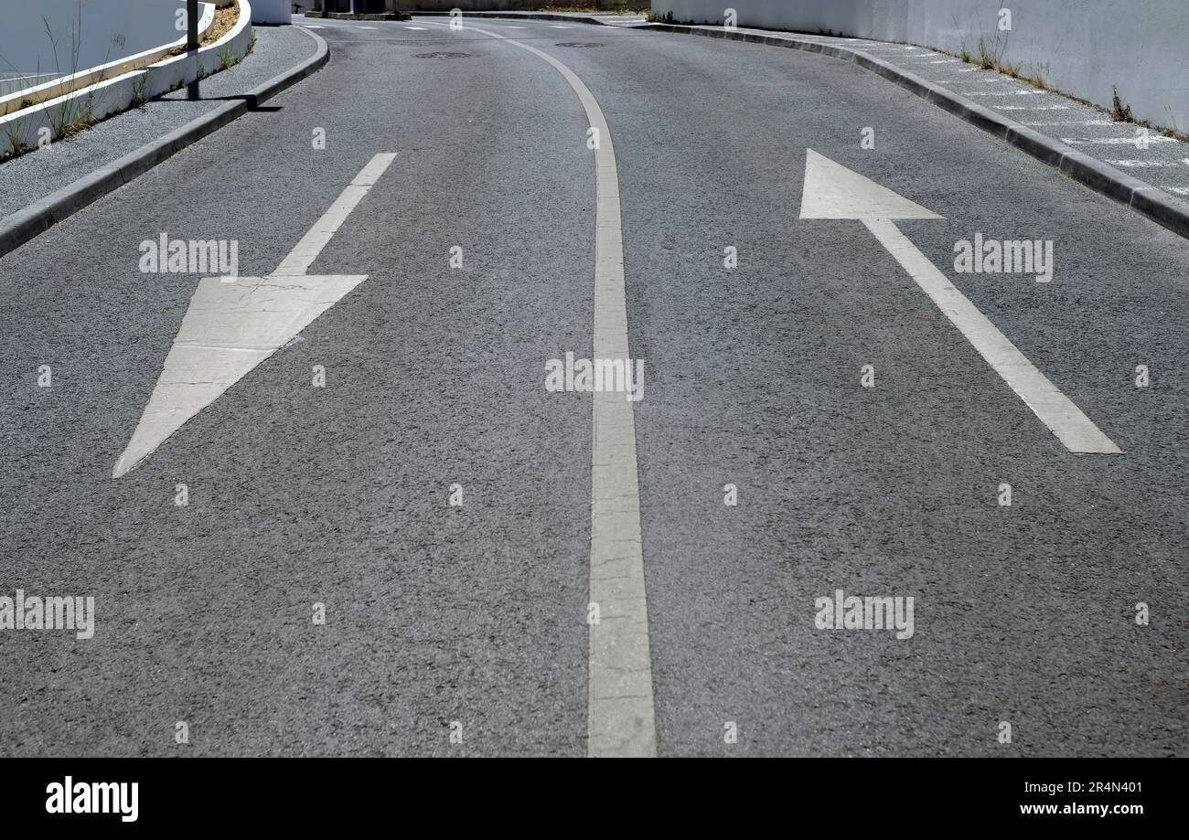 Road with two arrows pointing into opposite directions Stock Photo - Alamy