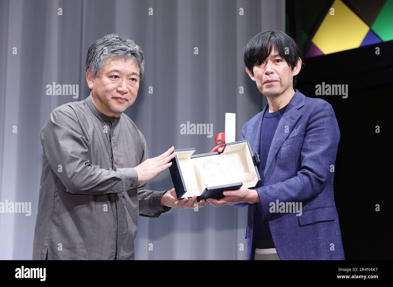 Japanese screenwriter Yuji Sakamoto (R) receives the Best Screenplay ...