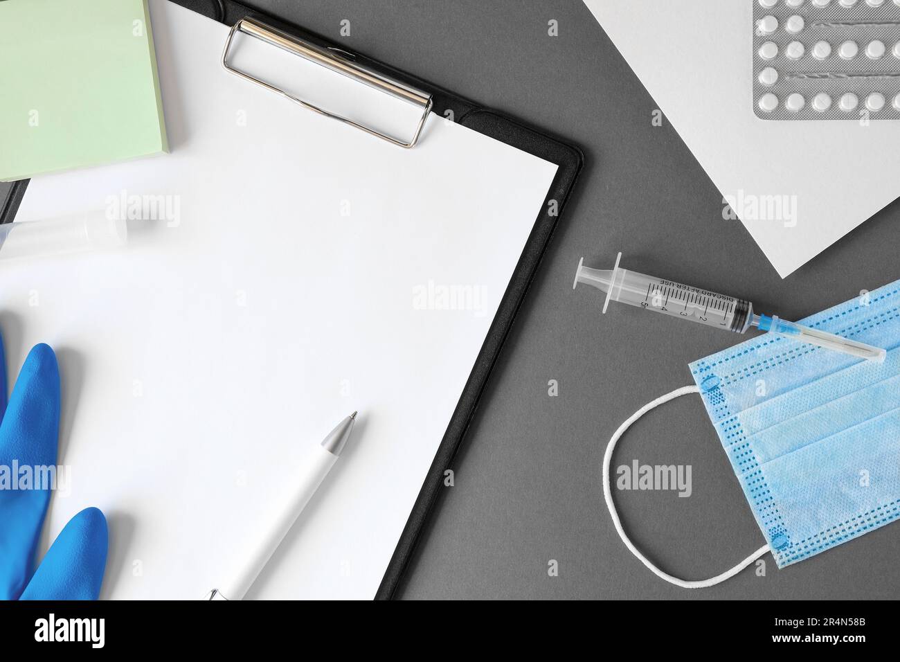 Gray modern doctor desk table with mask, notepad, syringe, sanitizer ...