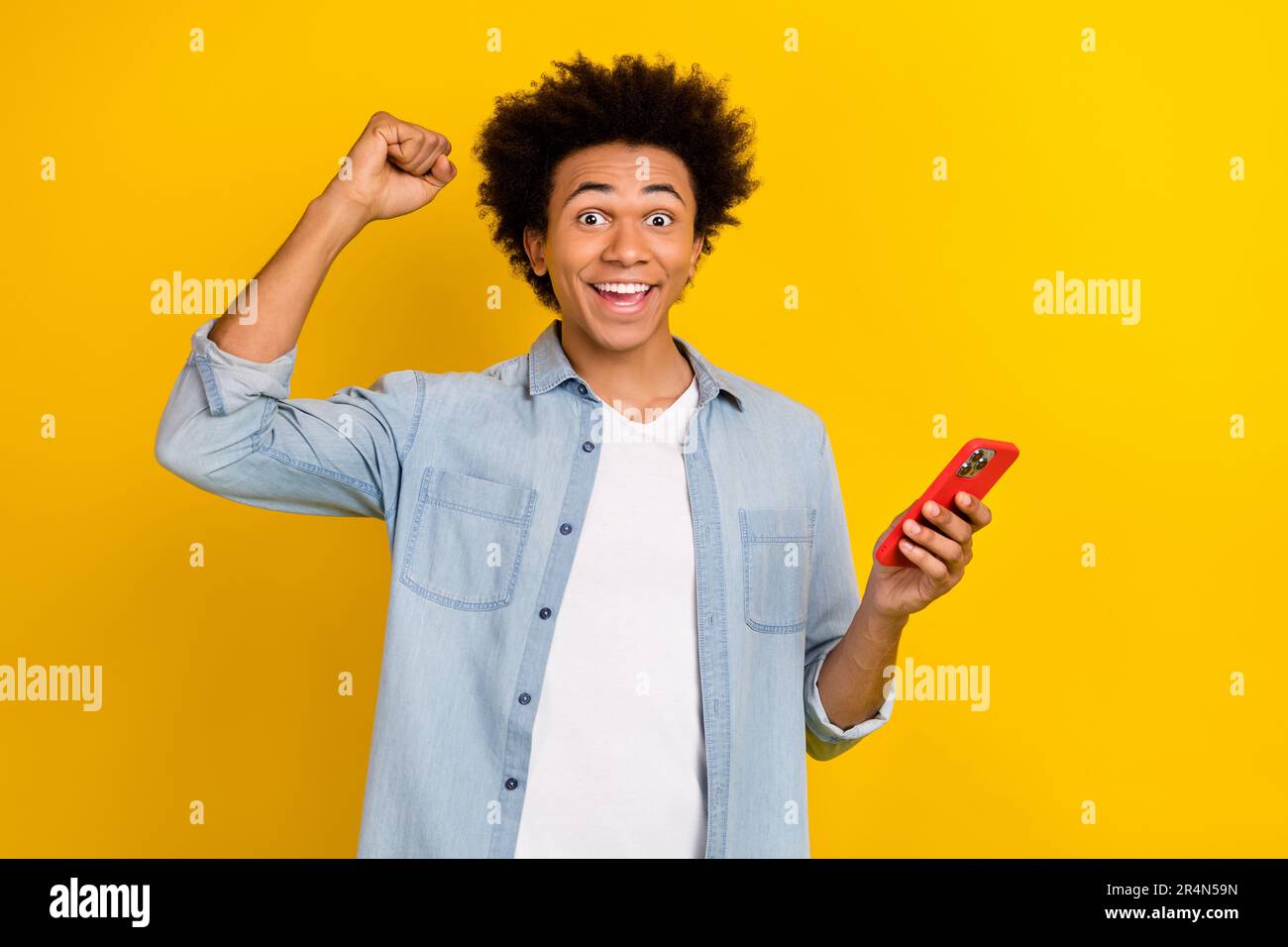 Photo of funky lucky guy dressed denim shirt rising fist texting apple ...