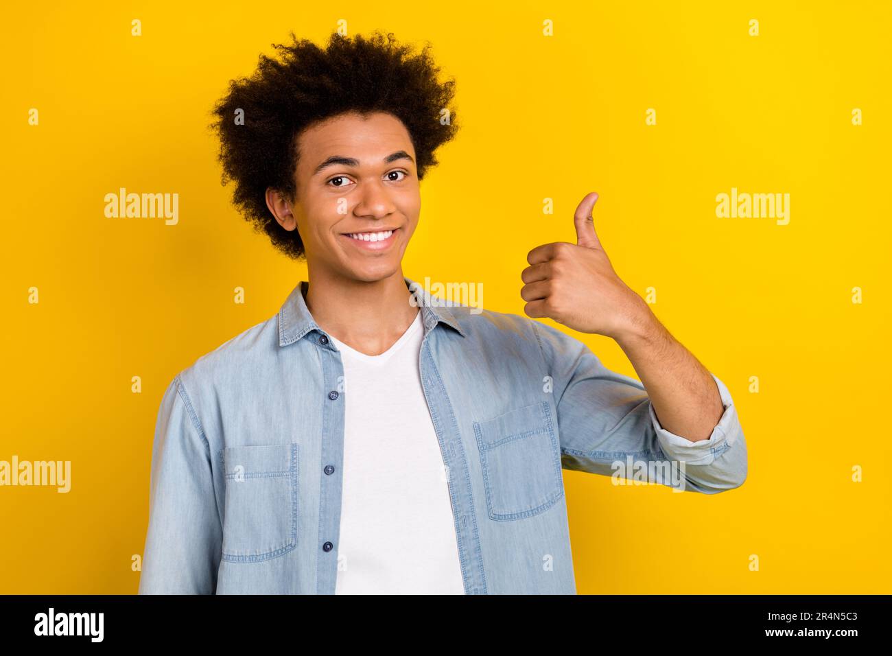 Photo of charming cool guy dressed denim shirt showing thumb up ...