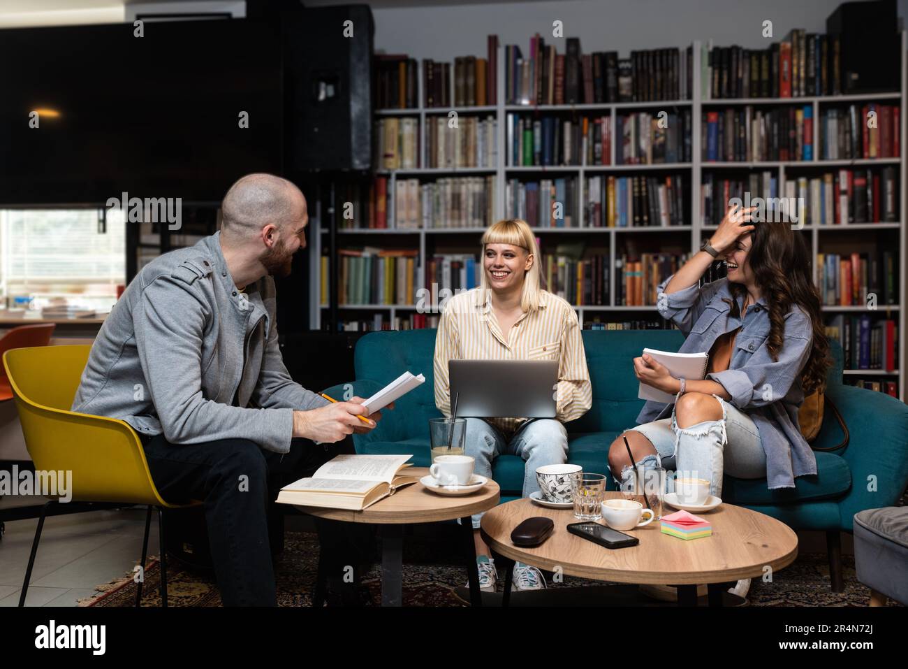 Group of three gen Z university students working together at laptop ...