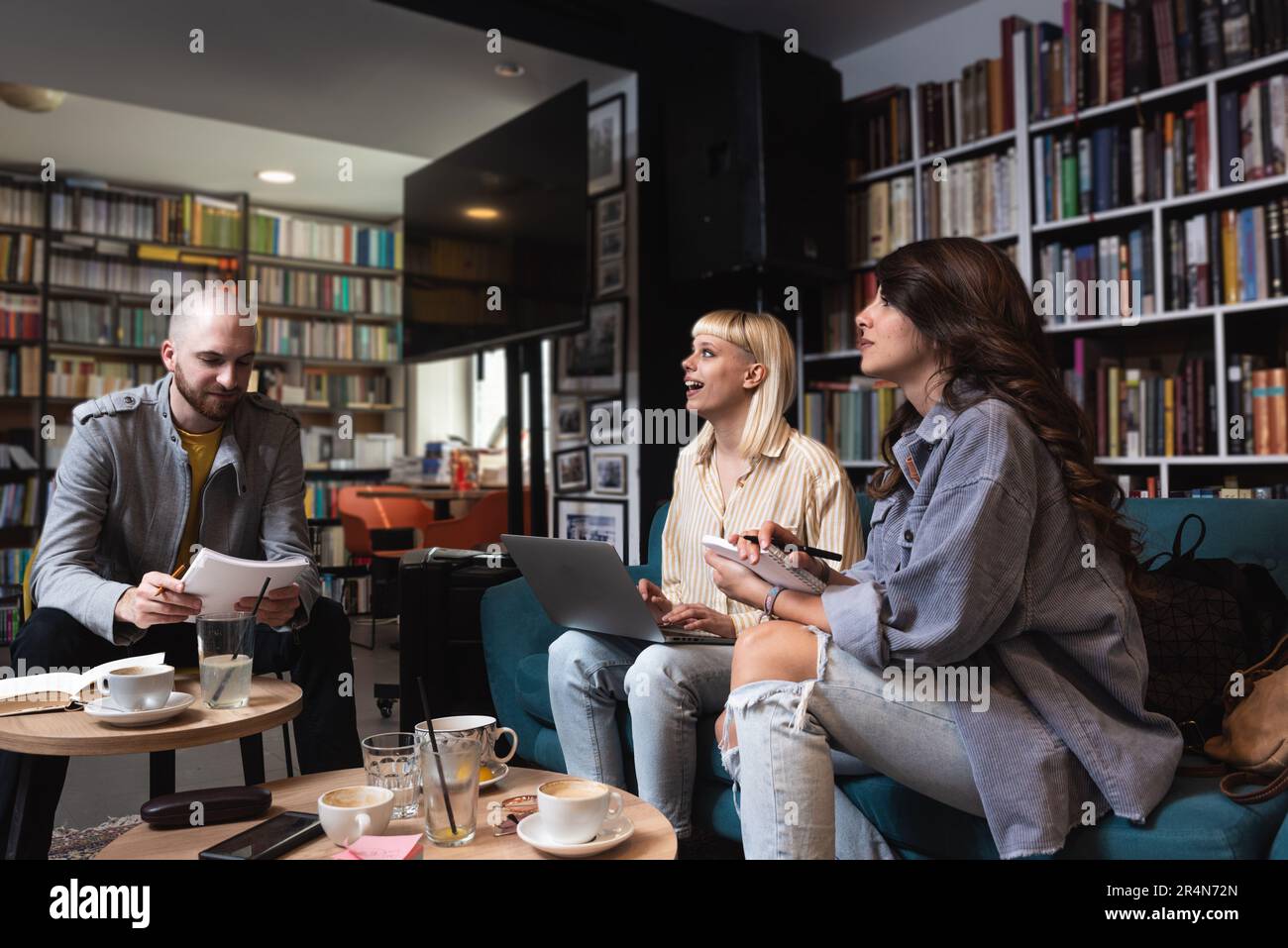 Group of three gen Z university students working together at laptop ...