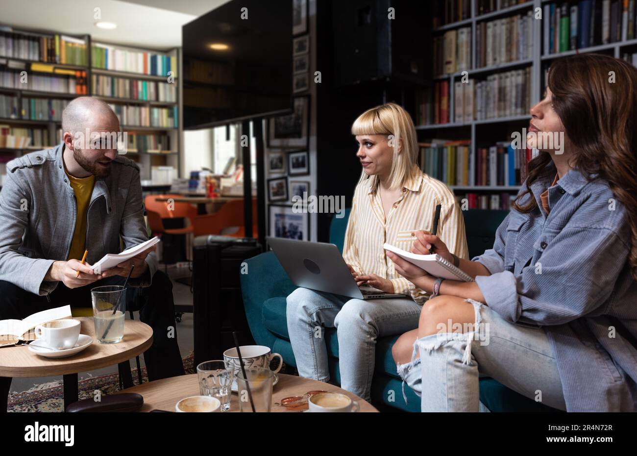 Group of three gen Z university students working together at laptop ...