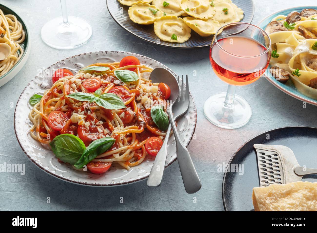 Italian dinner. Spaghetti marinara with wine, grated cheese, and other ...