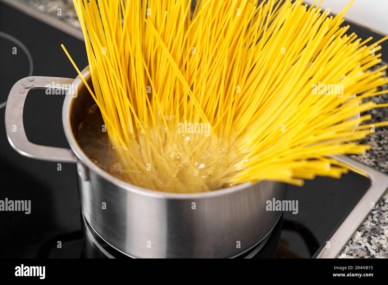Cooking spaghetti in a pot of boiling water on the stove Stock Photo ...